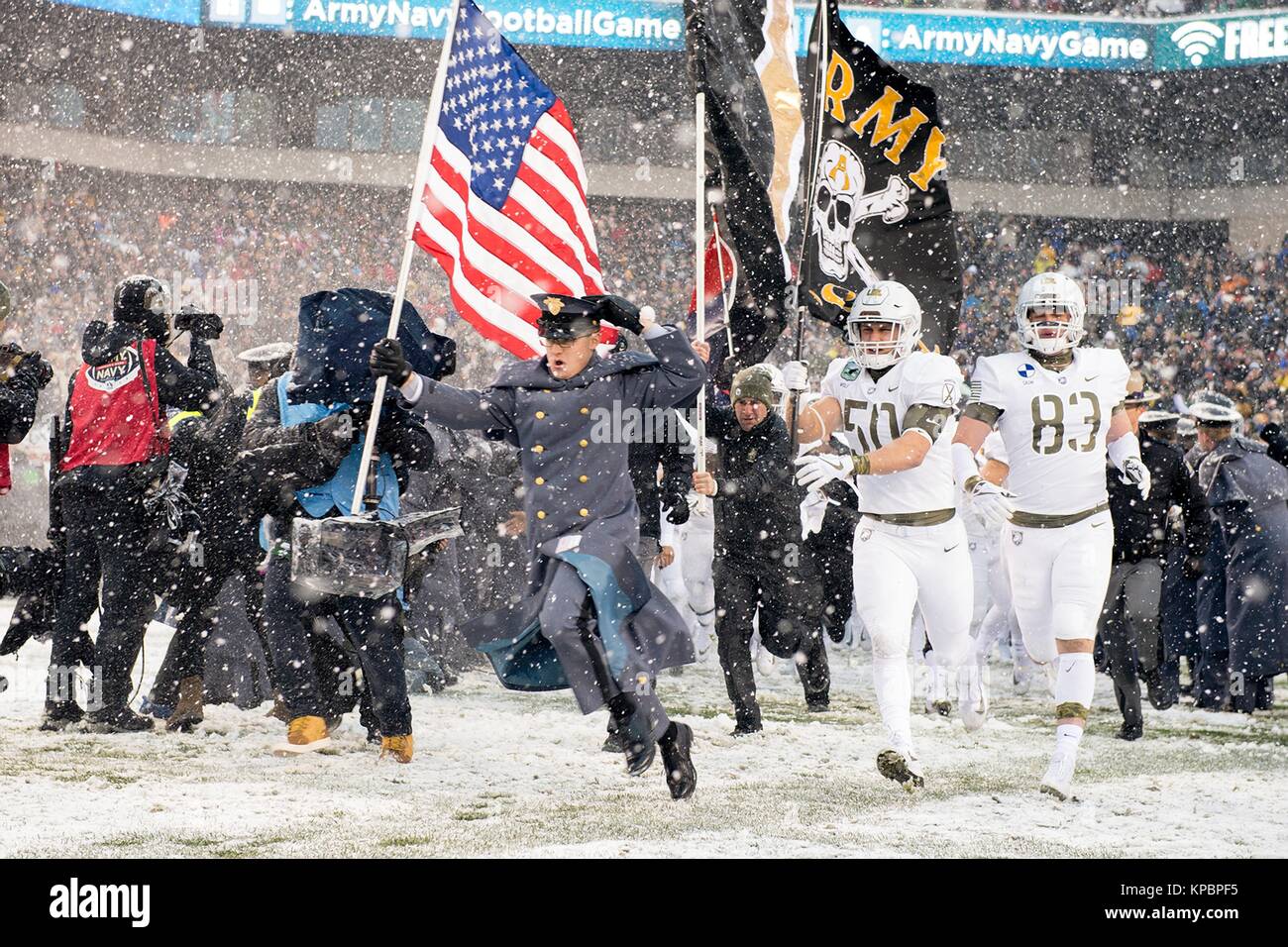 U.S. Army Military Academy Black Knights cadets and football players storm the field during the ...