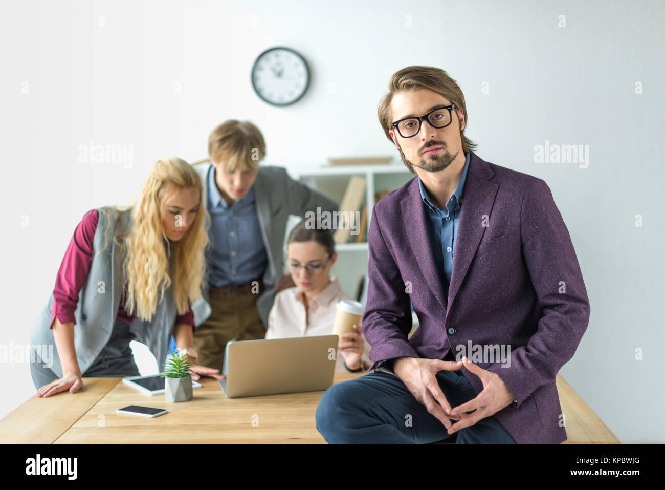 Team leader sitting on table Stock Photo - Alamy