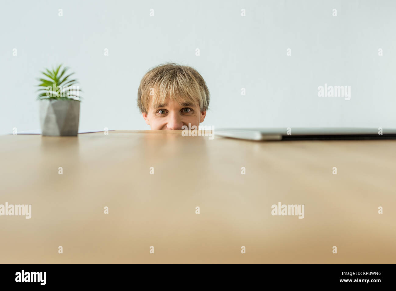 Man looking out from table Stock Photo - Alamy