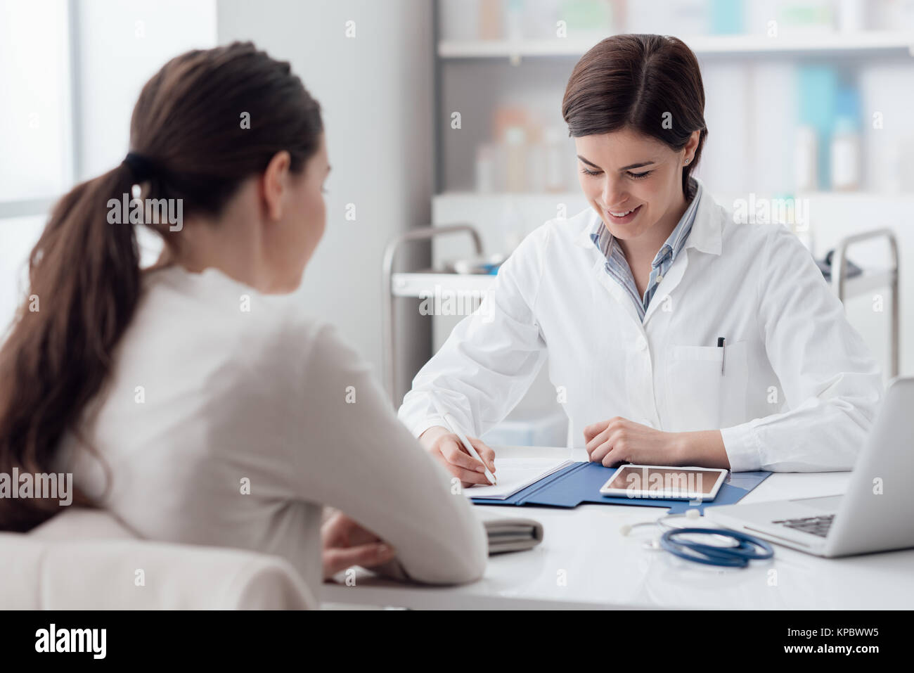Female doctor meeting with a patient in the office, she is giving a ...