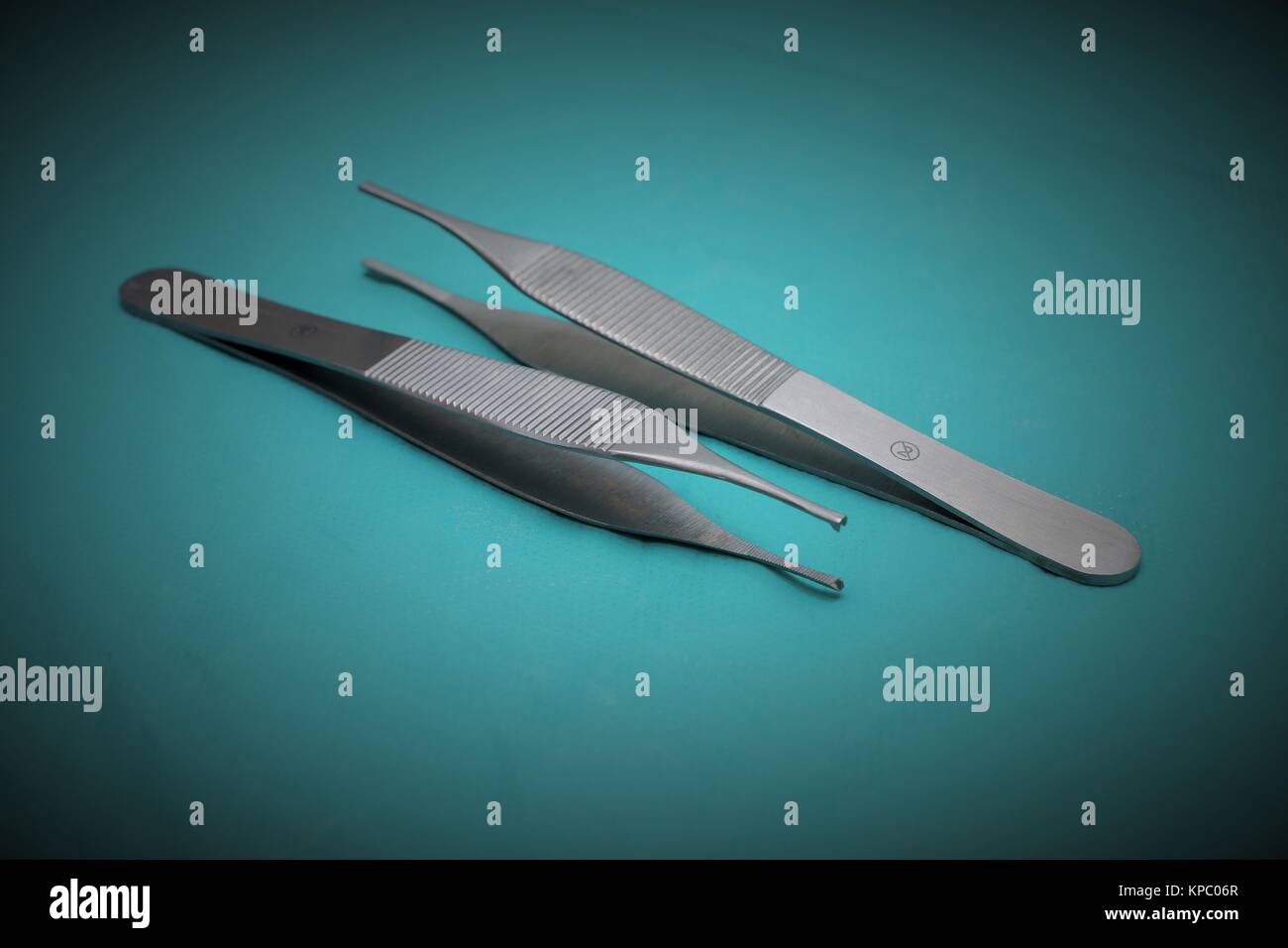 Two tweezers on a blue background Stock Photo - Alamy