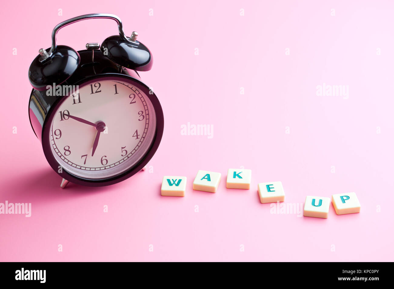 Wake up. alarm clock on pink background Stock Photo - Alamy
