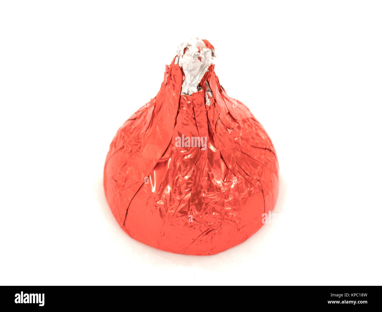 One piece of milk chocolate in red wrapping macro isolated on white ...