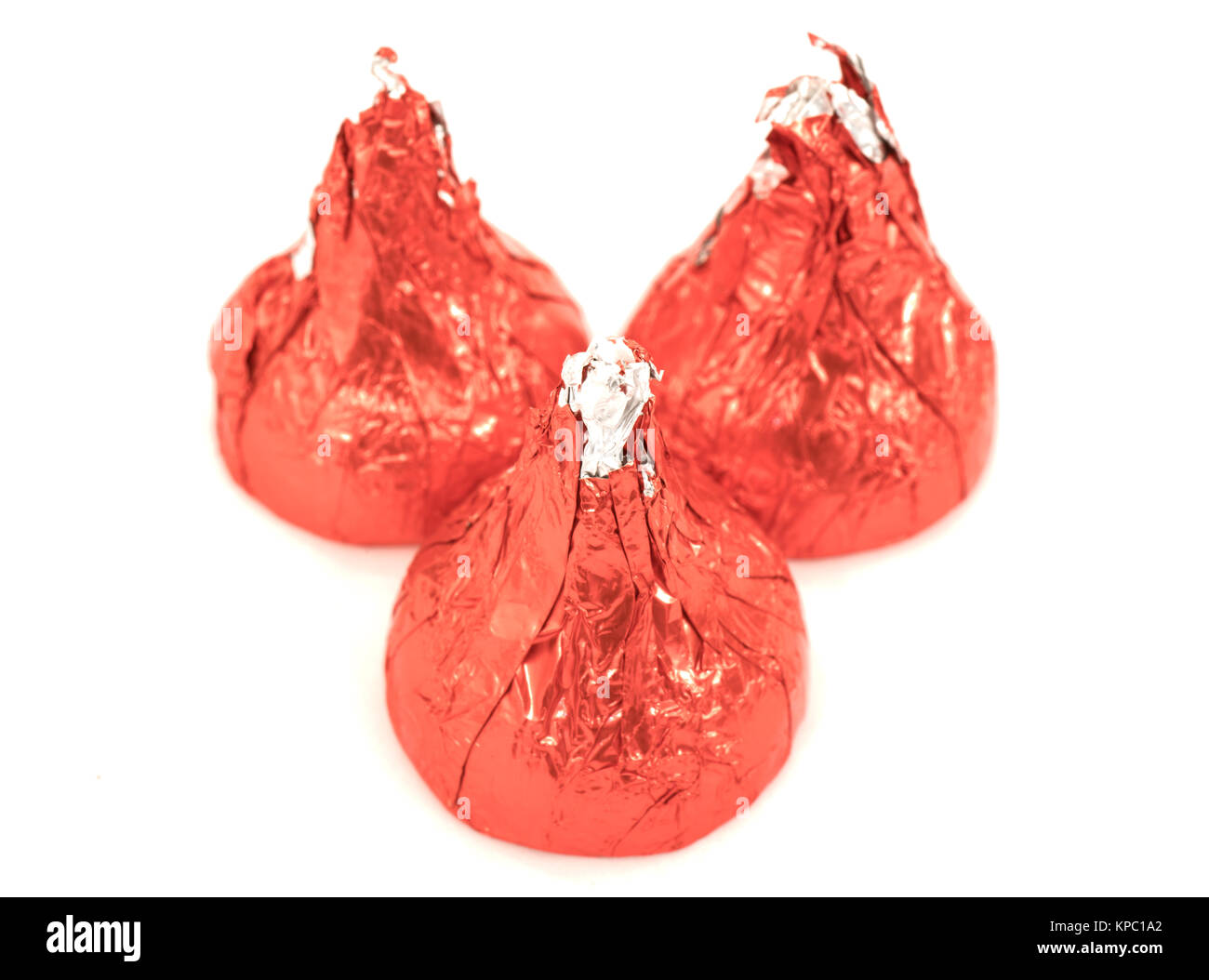 Three piece of milk chocolate in red wrapping macro isolated on white ...