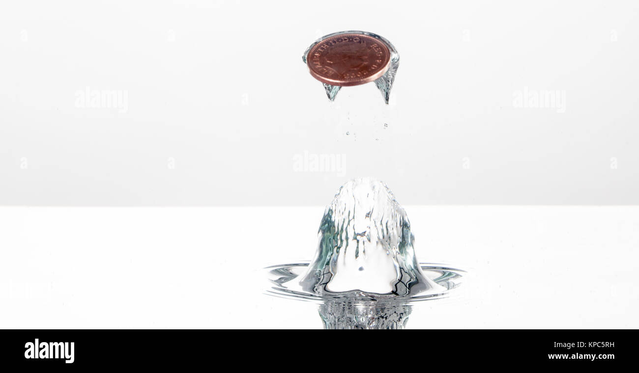 Coin splash in water caught with high speed photography, on a white ...