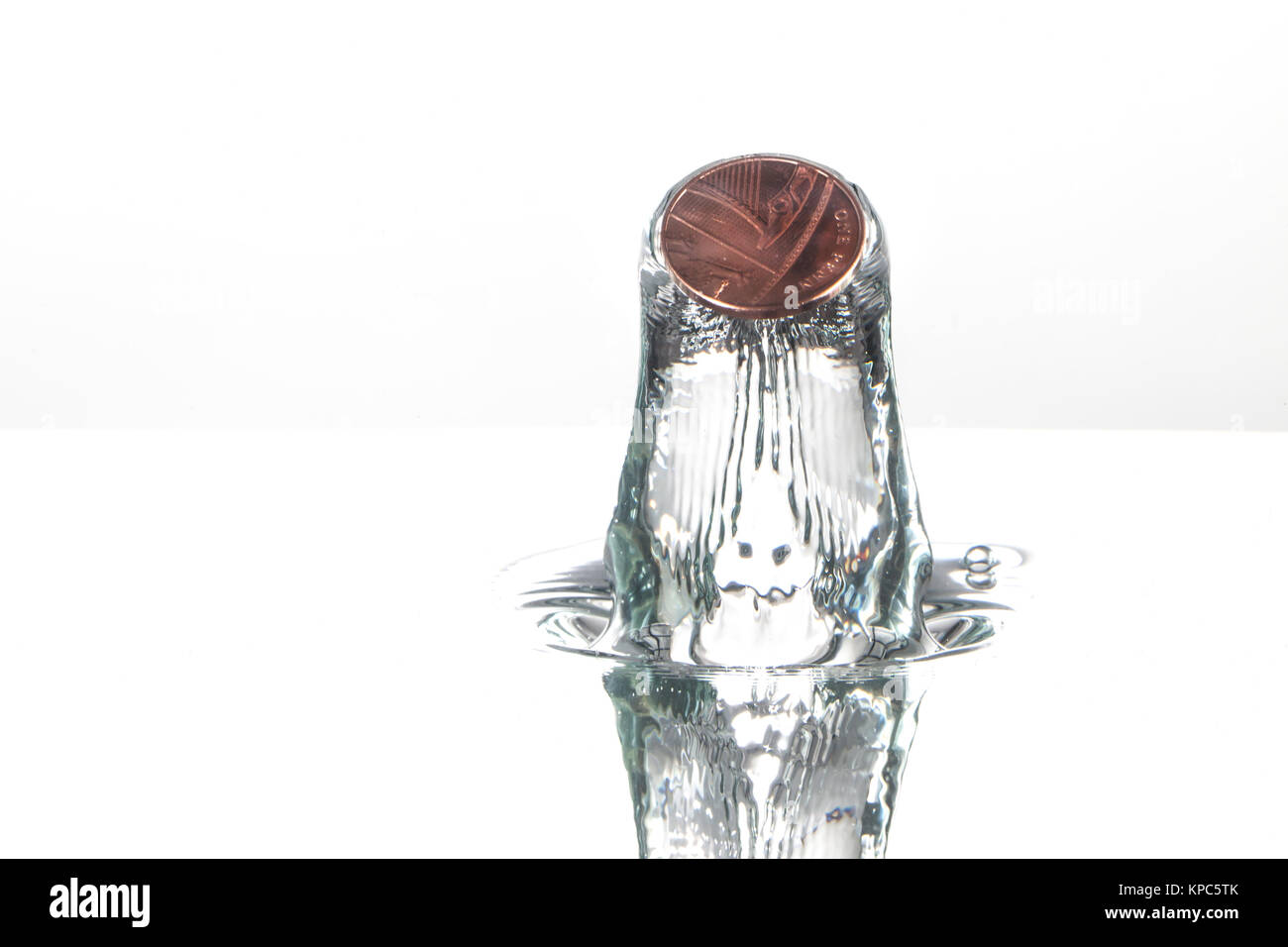 Coin splash in water caught with high speed photography, on a white ...