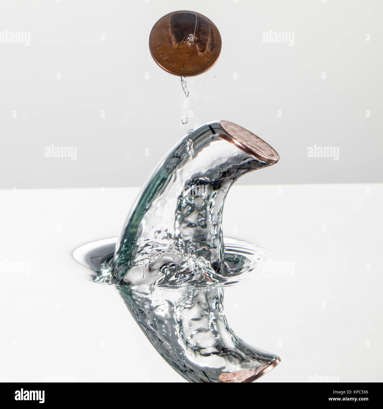Coin splash in water caught with high speed photography, on a white ...