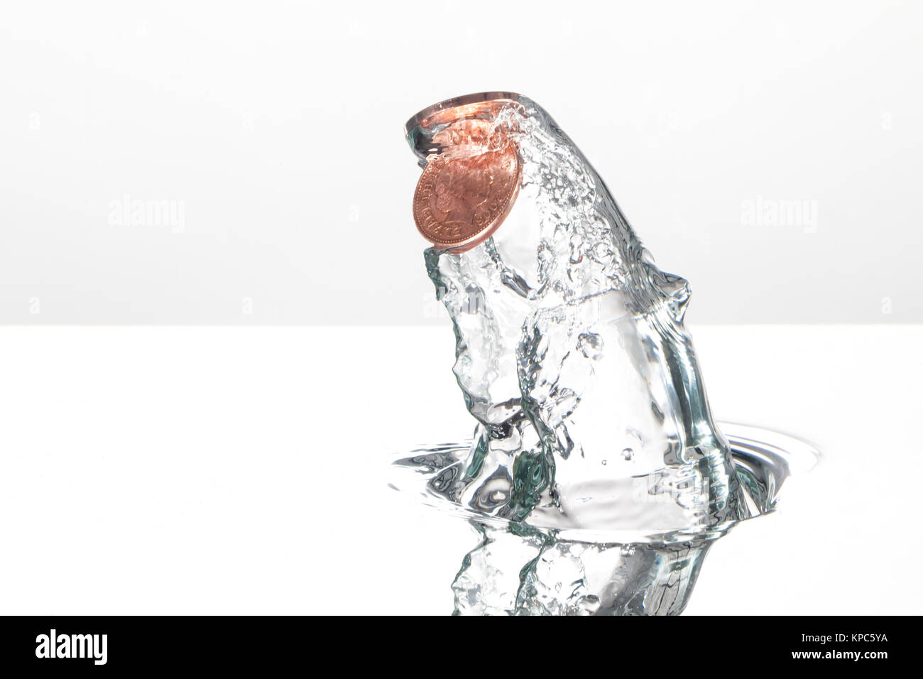 Coin splash in water caught with high speed photography, on a white ...