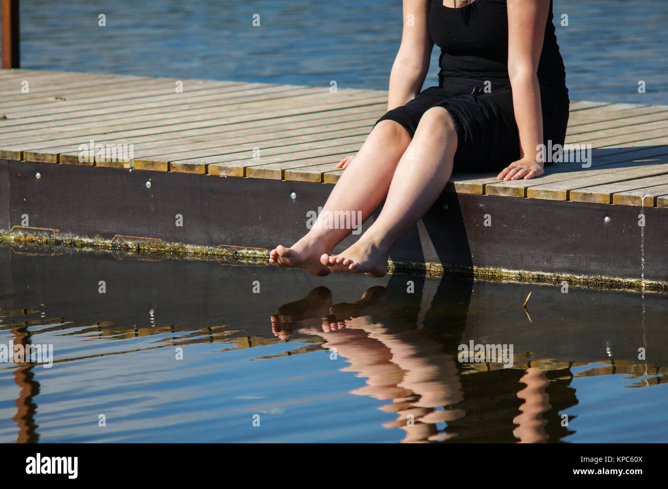 young lady sitting on the jetty Stock Photo - Alamy