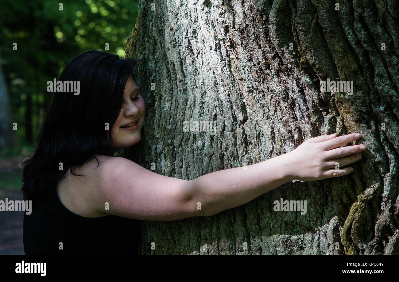 Young Woman hugging a Tree Stock Photo - Alamy