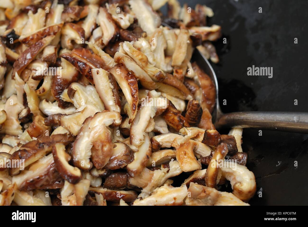 Cooking fragrant mushroom slices in traditional Chinese wok Stock Photo ...