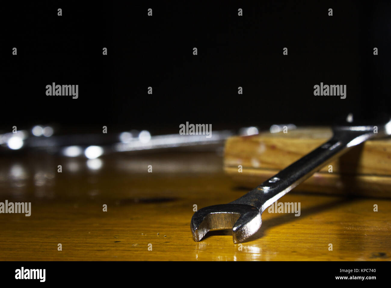 Horizontal photo of a metallic silver spanner on a wood table Stock ...