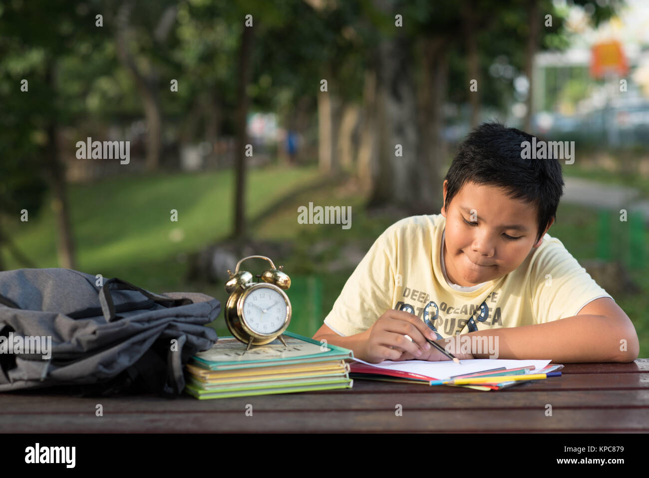 young asian boy having fun drawing at park in the evening sunny day ...