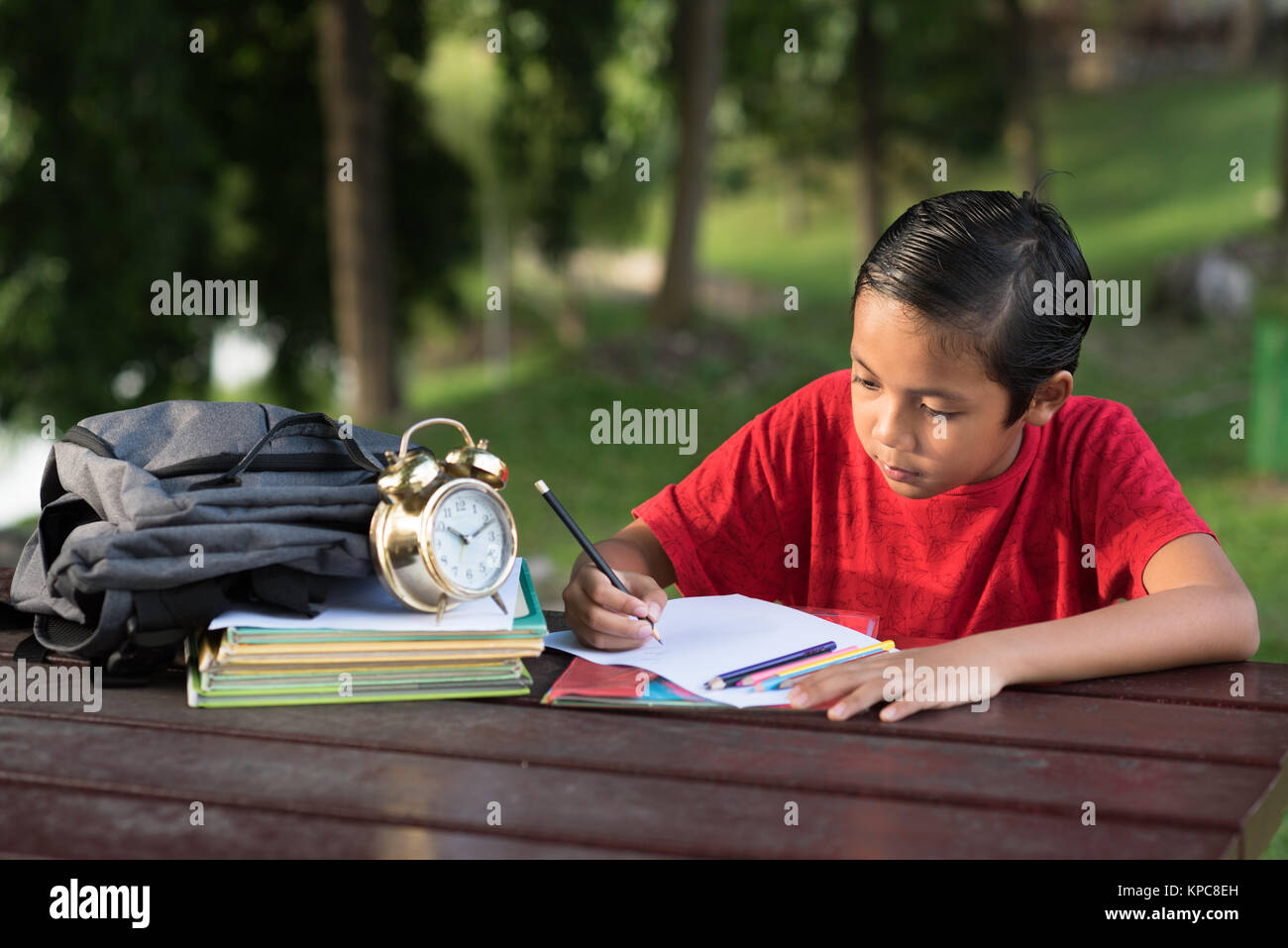 young asian boy having fun drawing at park in the evening sunny day ...