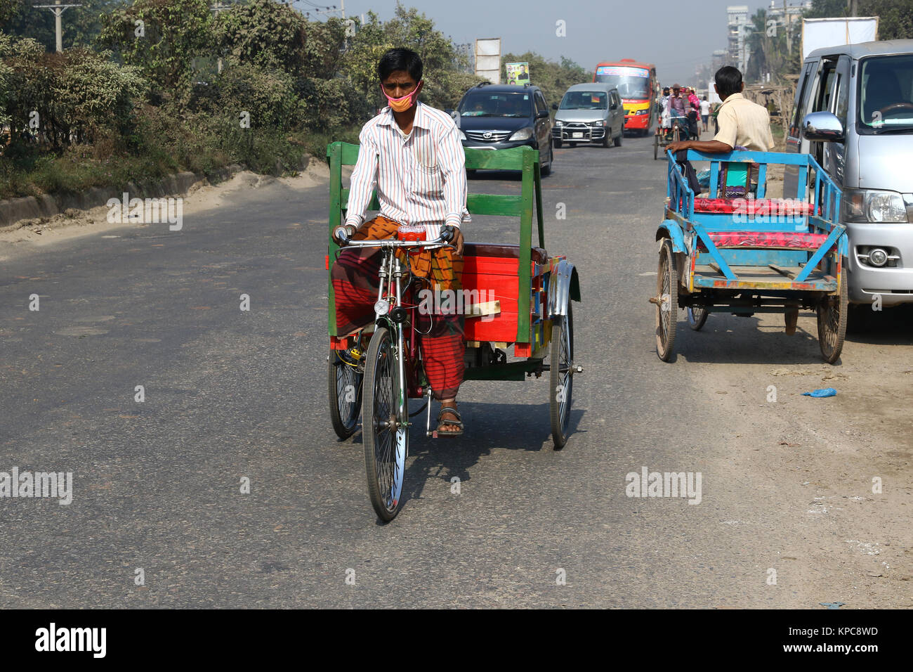 A battery-run rickshaw plying the Dhaka-Aricha highway near Amin Bazar ...