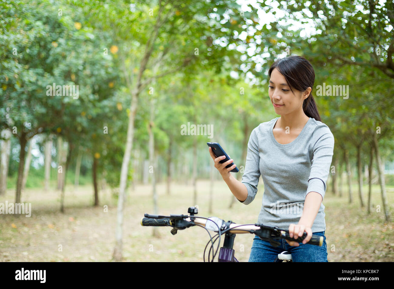 Woman checking the GPS on mobile phone when cycling Stock Photo - Alamy