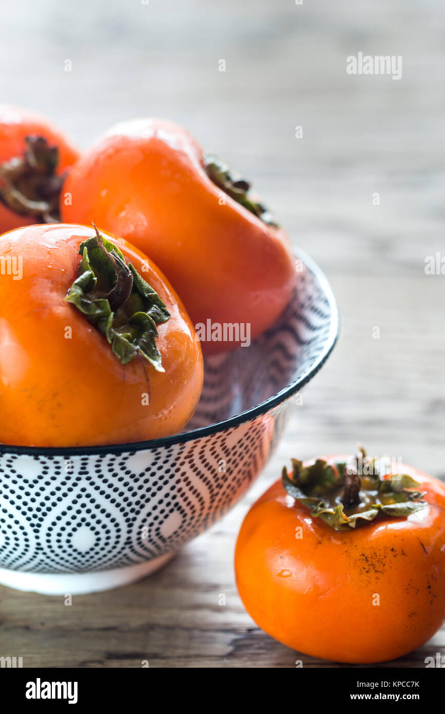 Bowl of fresh persimmons Stock Photo - Alamy