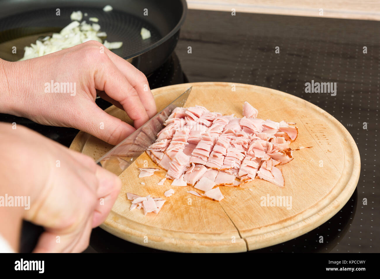 Cooking: cutting ham in small pieces in a modern kitchen Stock Photo ...