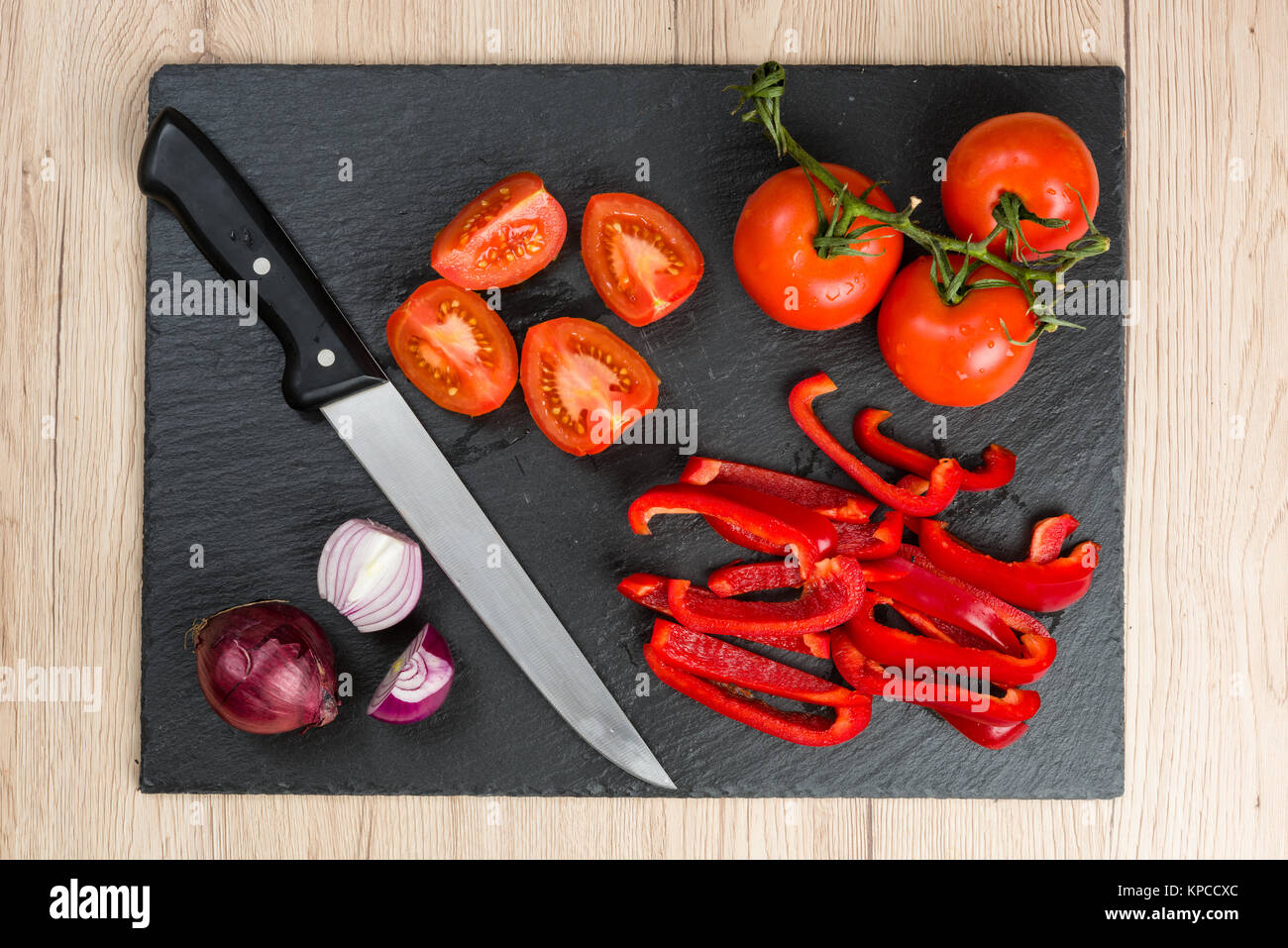 Top down view on black cutting board with sliced vegetables Stock Photo ...