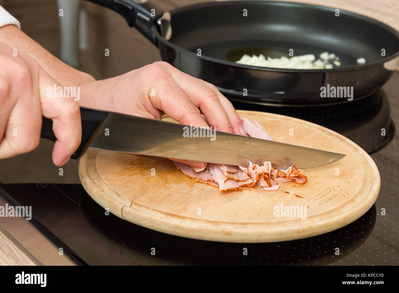 Cooking: cutting ham in small pieces in a modern kitchen Stock Photo ...