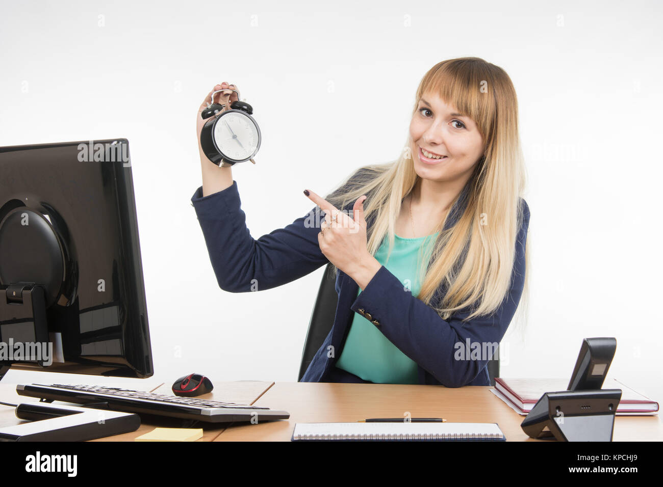 Office specialist in after-hours shows the clock Stock Photo - Alamy