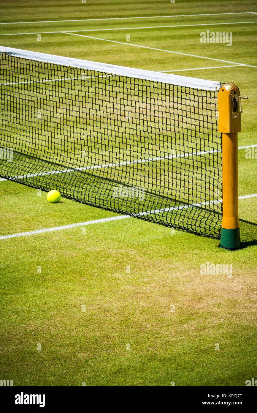 Tennis ball rest by net on grand court Stock Photo - Alamy