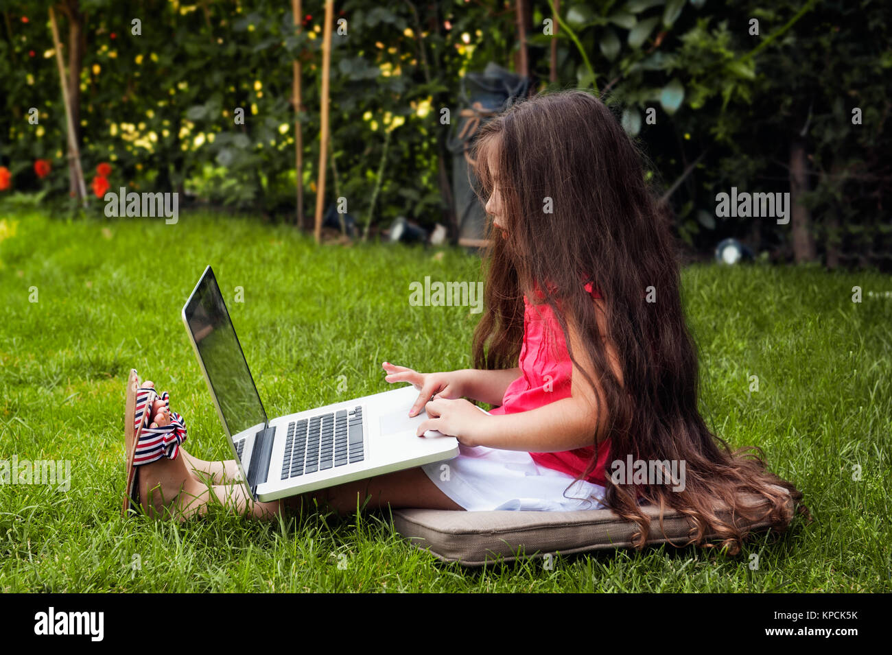 Child on green grass using laptop computer Stock Photo - Alamy