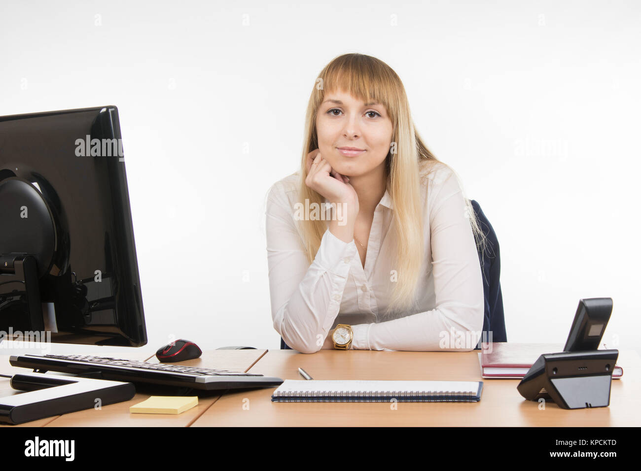 Business woman sitting at a desk in the office and looking at the frame ...