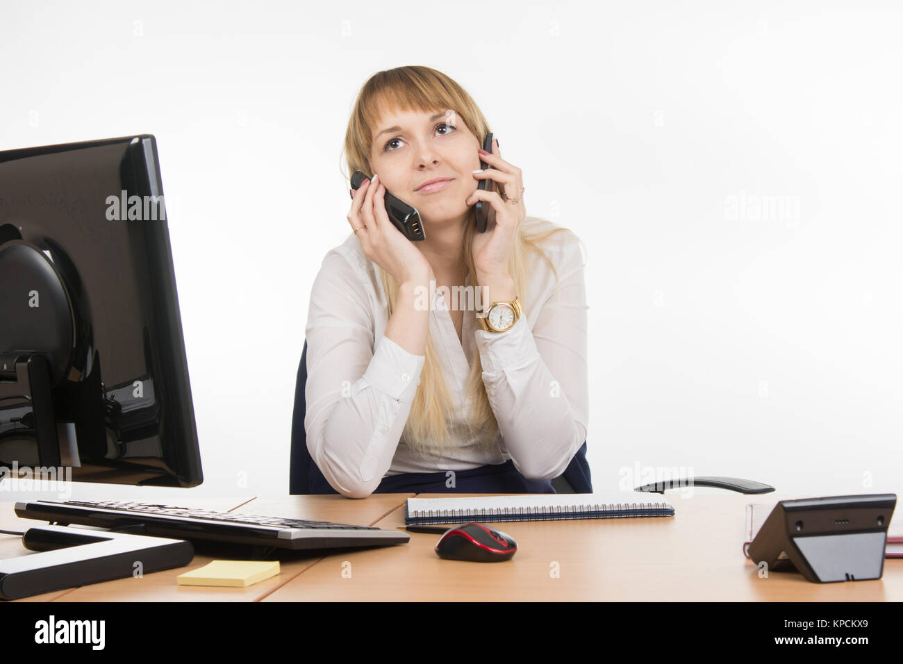 Secretary talking on two phones at once - and the working cell Stock ...