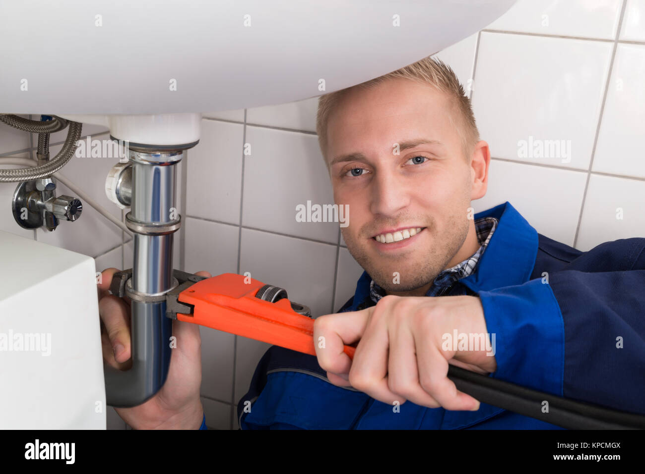 Male Plumber Fixing Sink In Kitchen Stock Photo - Alamy