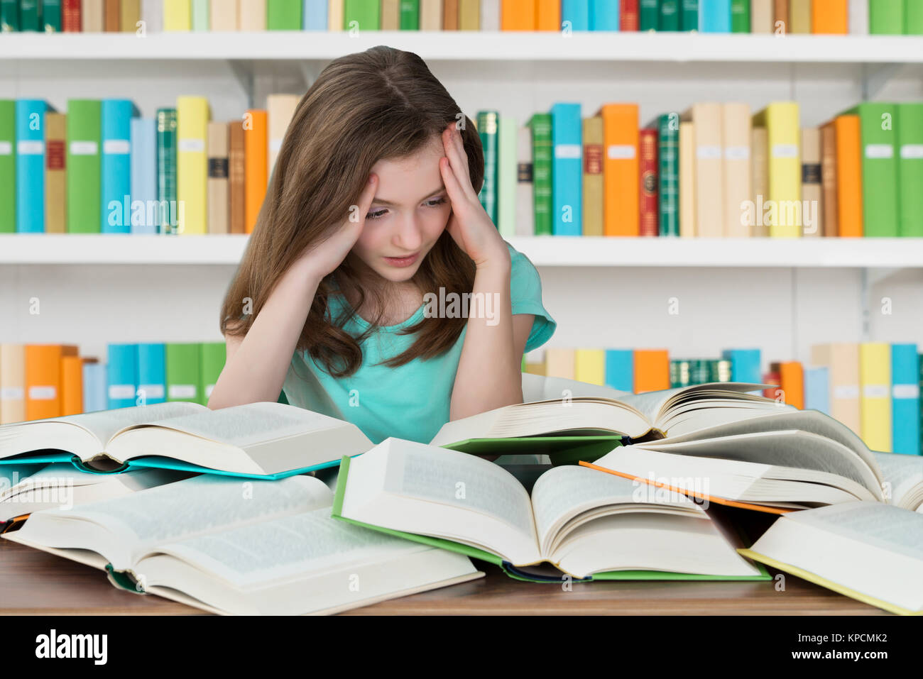 Overburdened Schoolgirl Studying In Library Stock Photo - Alamy