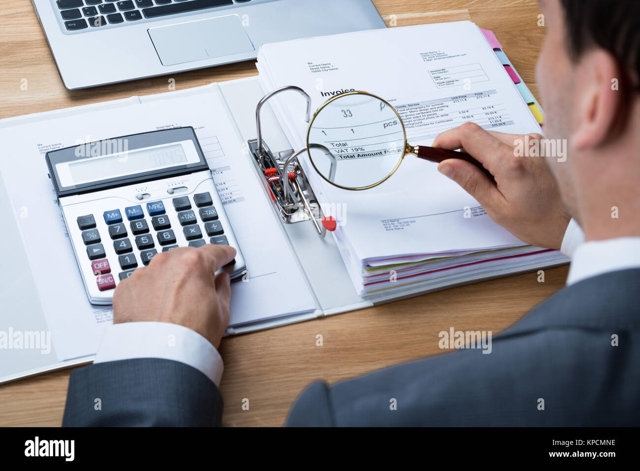 Businessman Examining Invoice With Magnifying Glass Stock Photo - Alamy