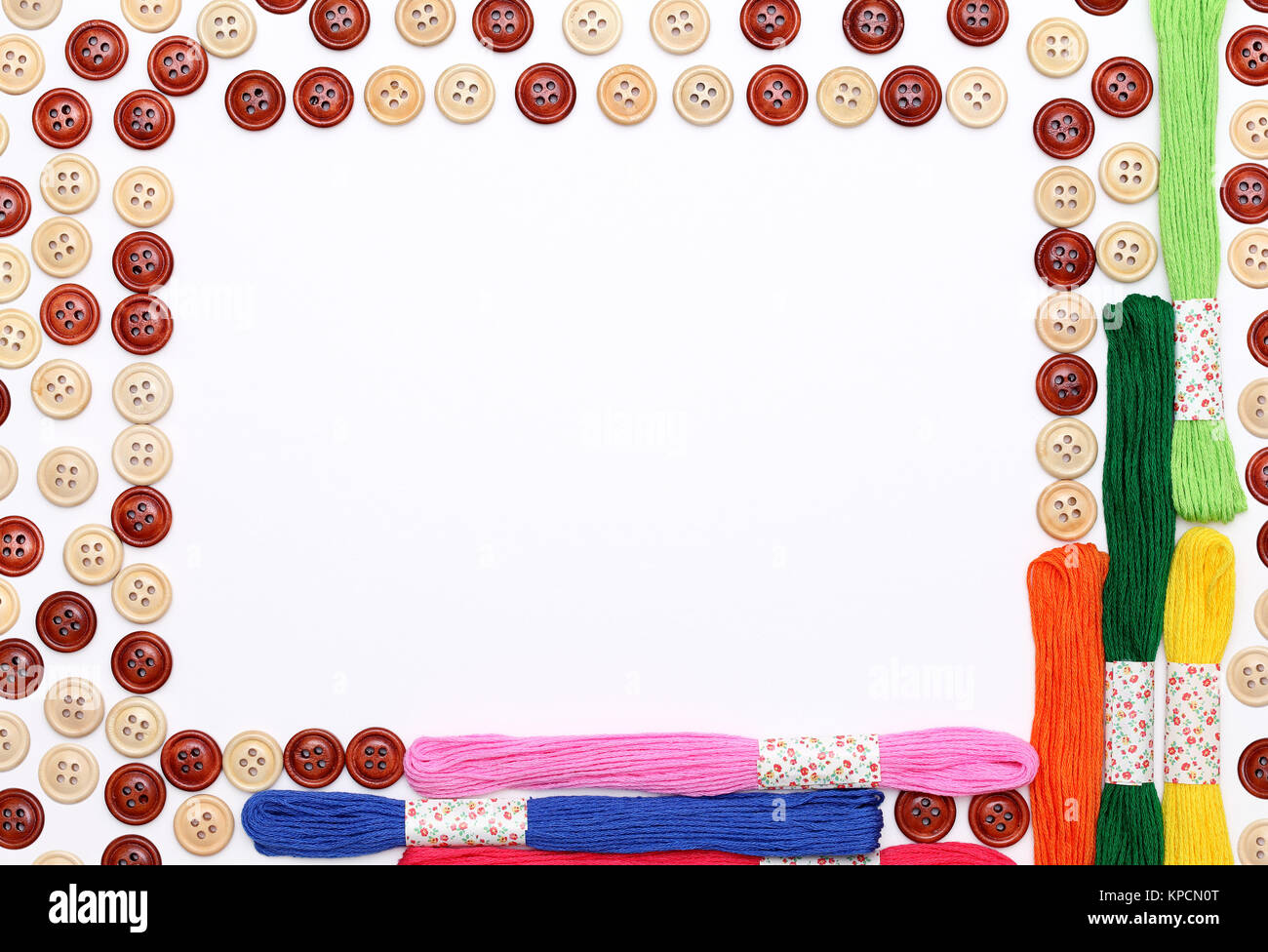 Sewing buttons and threads frame on white background Stock Photo - Alamy