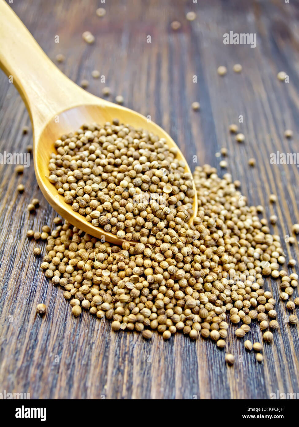 Coriander seeds in spoon on board Stock Photo - Alamy