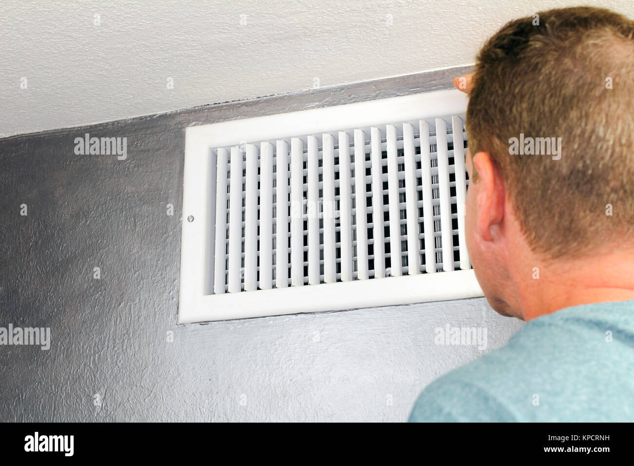 Man Looking in an Air Vent Stock Photo - Alamy
