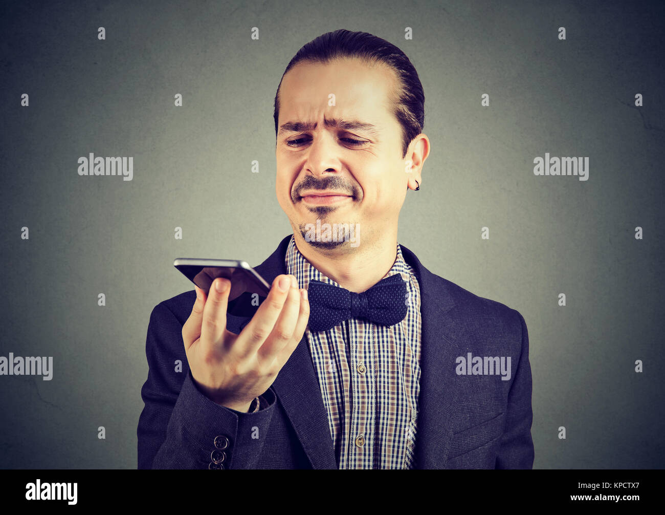 Man in formal clothing holding phone and looking discontented with new ...