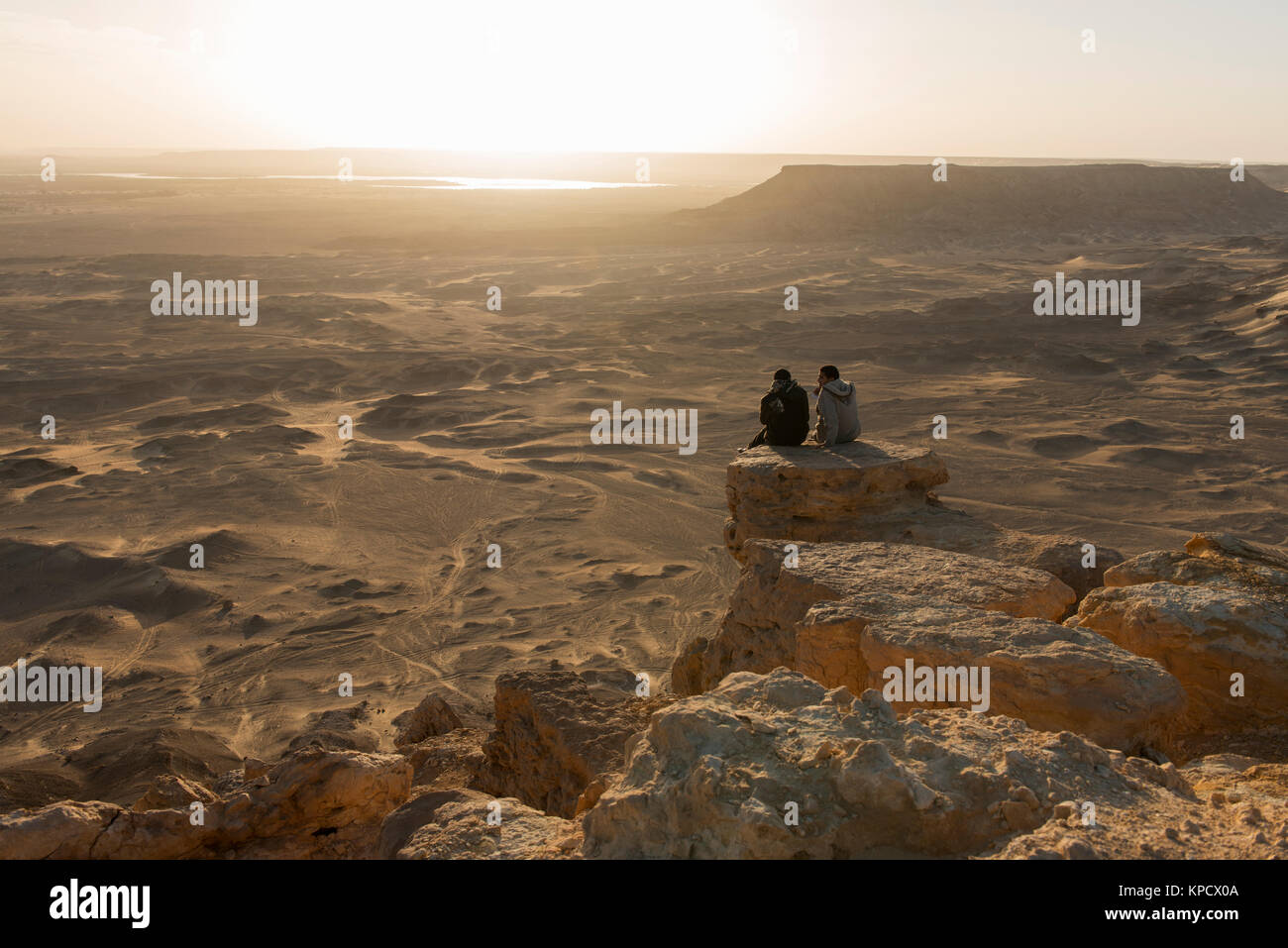 Two boys looking at the sunset from the top of Gebel Dist, with a view ...