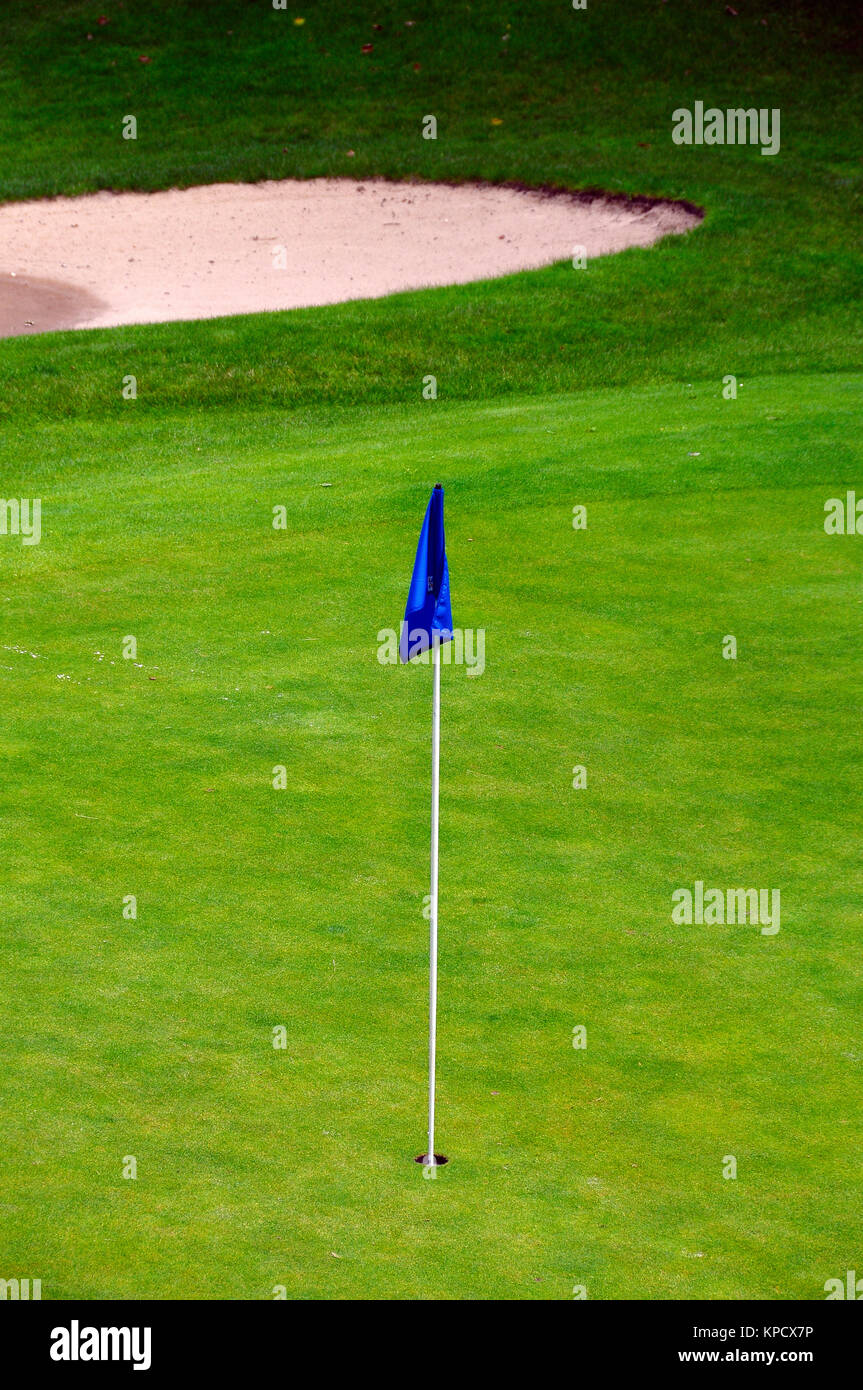Part of golf course with blue flag and hole in green lawn Stock Photo ...