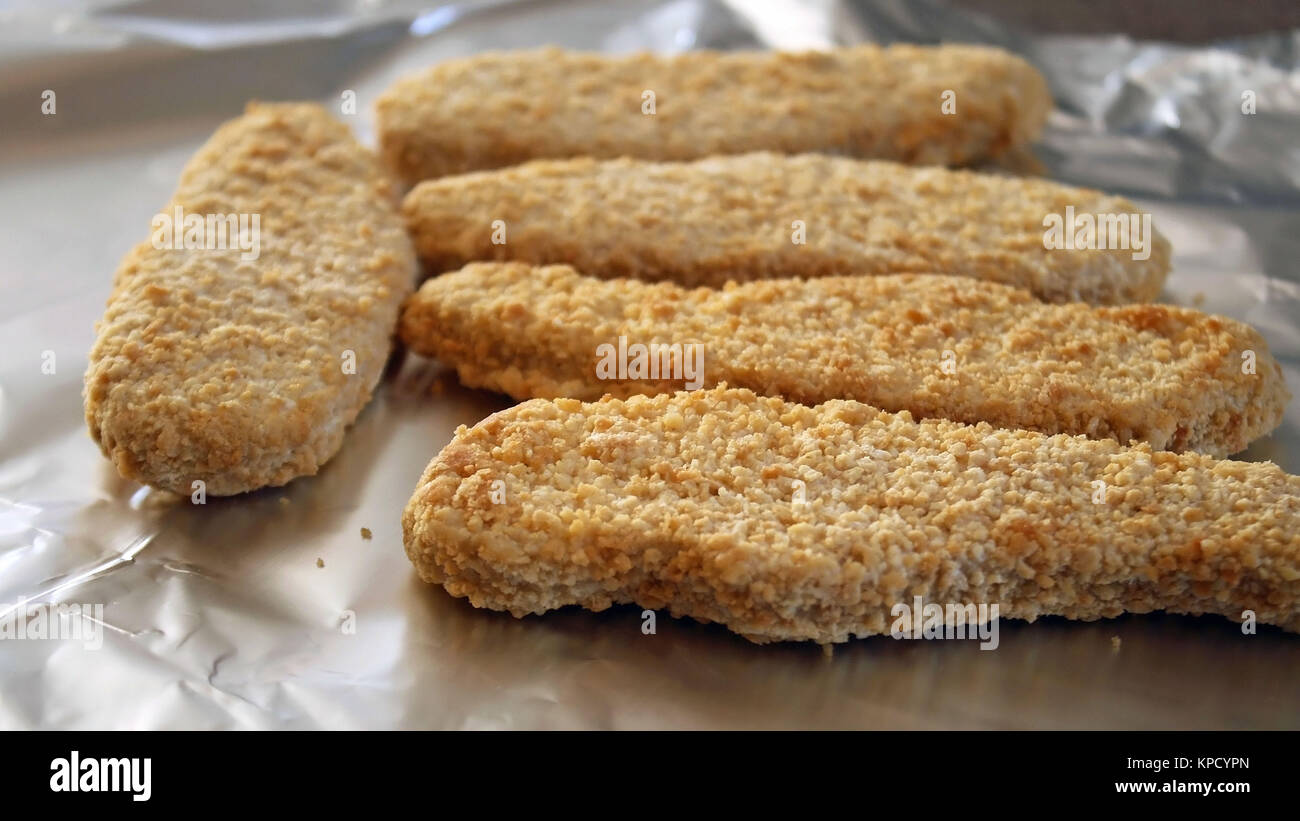 Boxed frozen chicken strips on aluminum foil ready to go into the oven ...