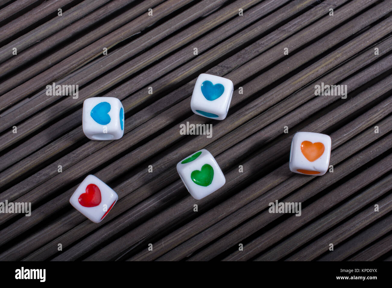 Colorful heart shaped love cubes on a straw mat Stock Photo - Alamy
