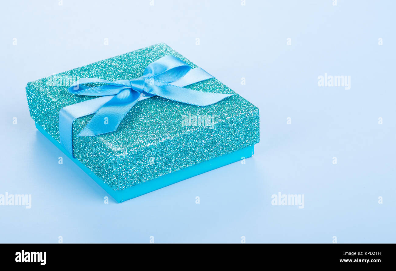 Blue gift box with ribbon and bow on a blue background Stock Photo - Alamy