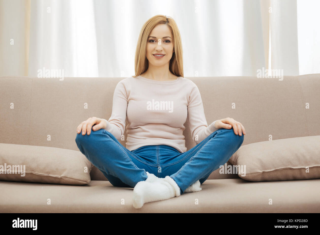 Beautiful smiling woman sitting on the sofa Stock Photo - Alamy