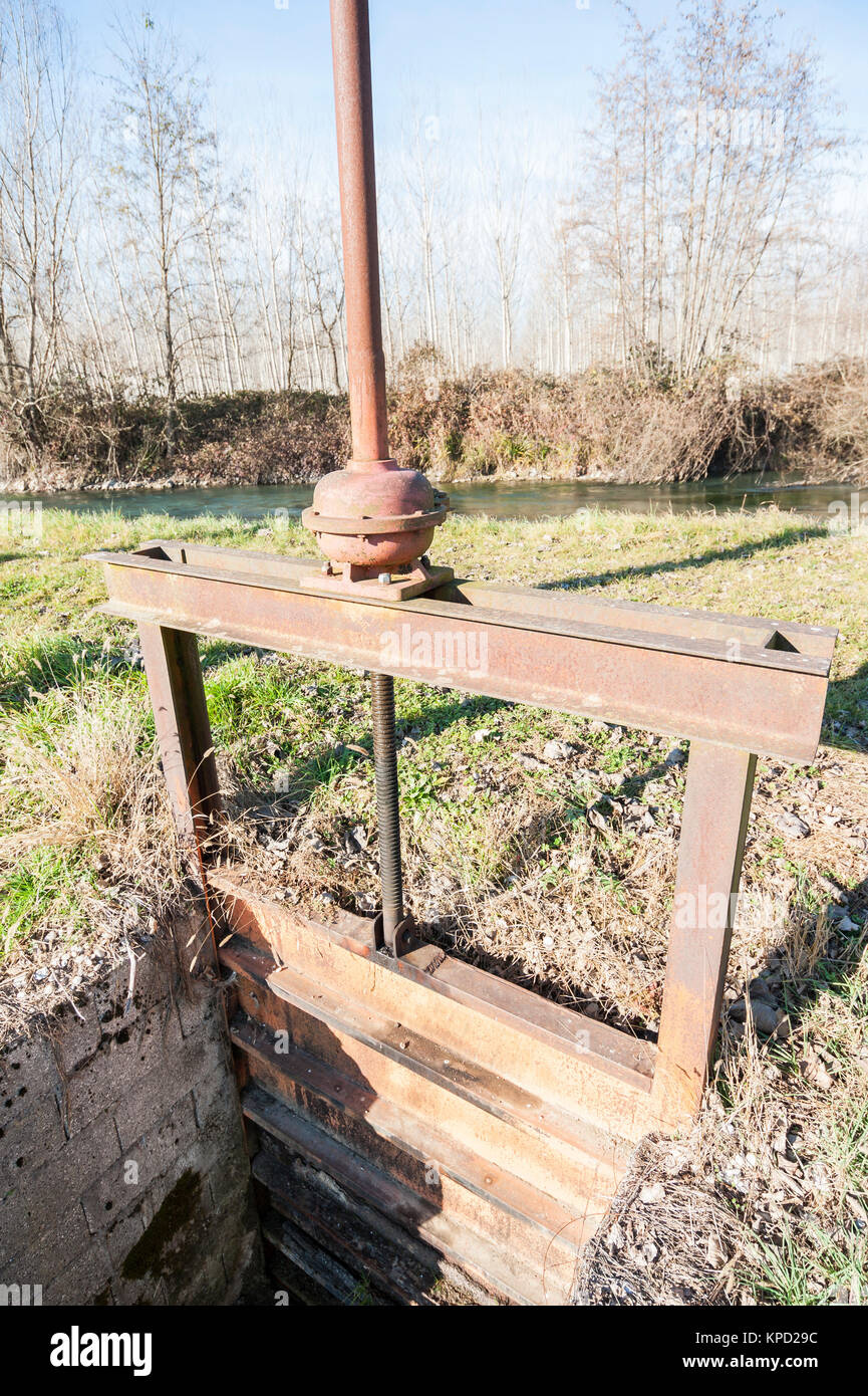 Irrigation Canal and old and manual Flood gate valve Stock Photo - Alamy