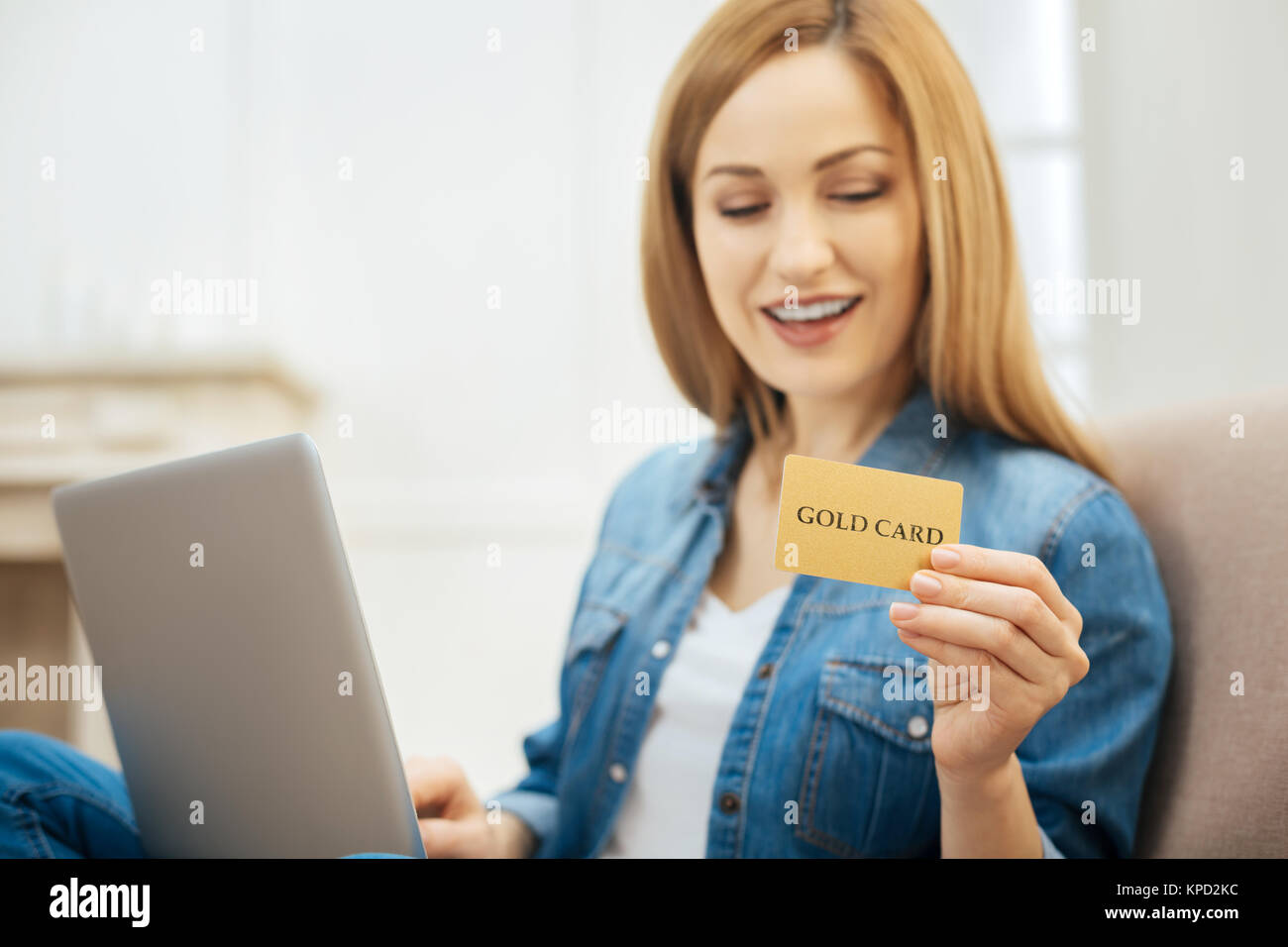 Alert woman looking at her gold card Stock Photo - Alamy