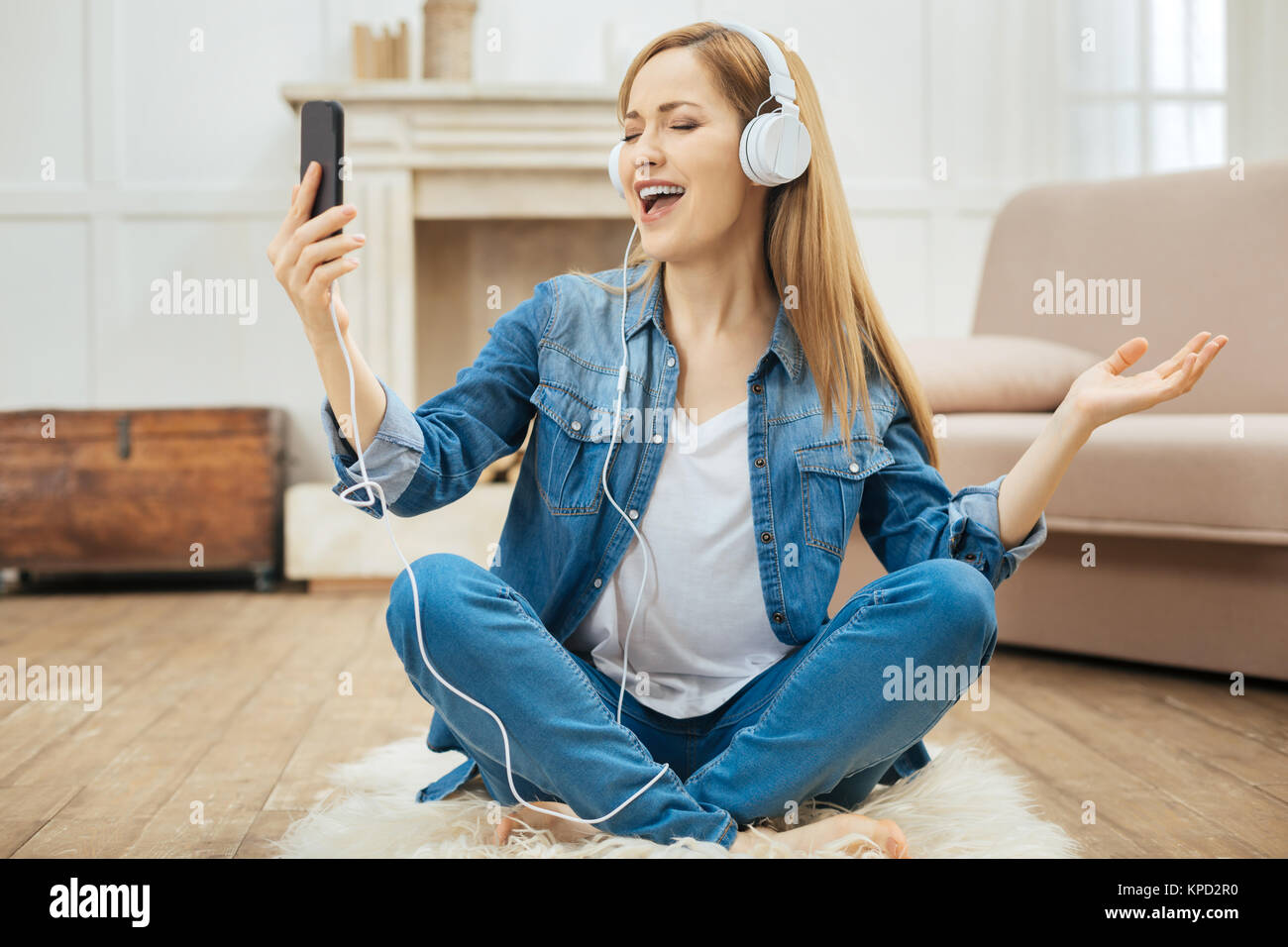 Cheerful woman singing while listening to music Stock Photo - Alamy