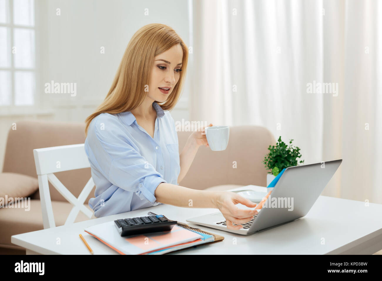 Smiling woman putting stickers on her computer Stock Photo - Alamy