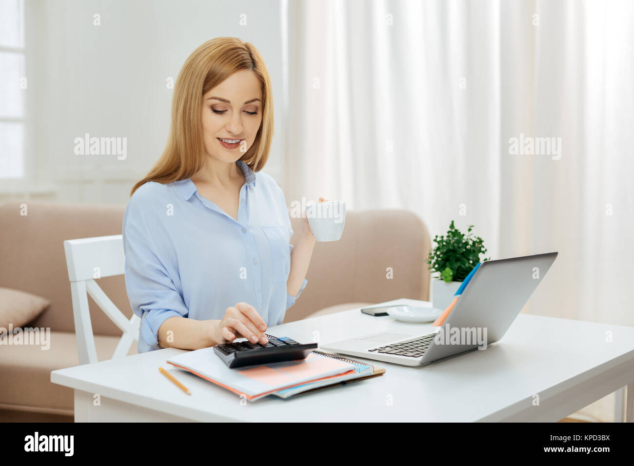 Successful smiling woman making calculations Stock Photo - Alamy