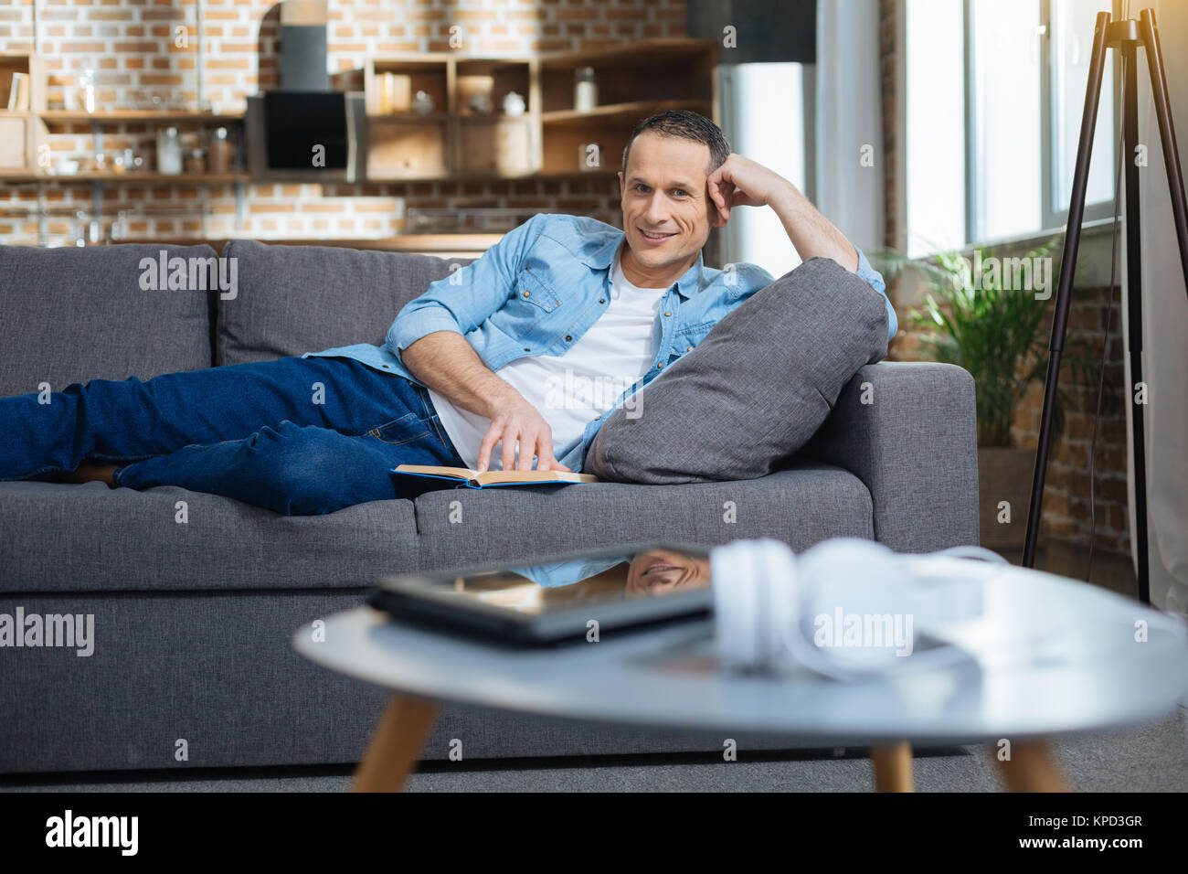 Handsome man posing on his sofa Stock Photo - Alamy