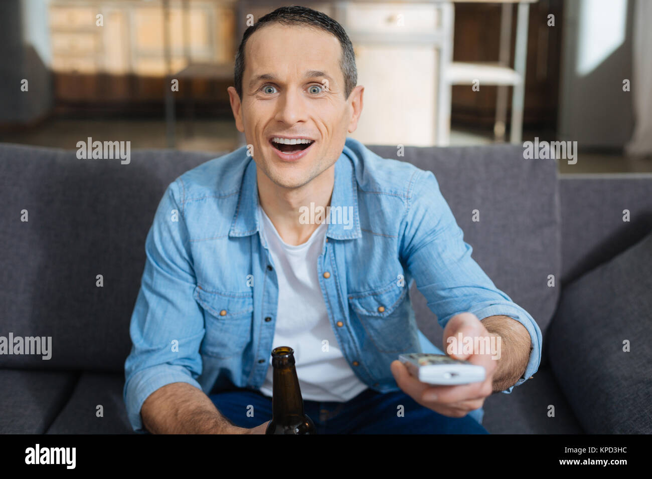 Happy young man being very pleased Stock Photo - Alamy
