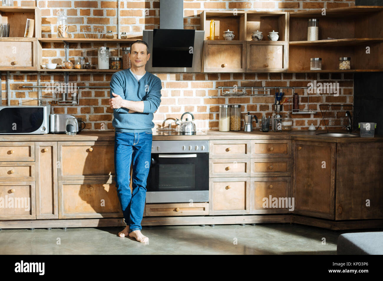 Confident man standing in the kitchen Stock Photo - Alamy